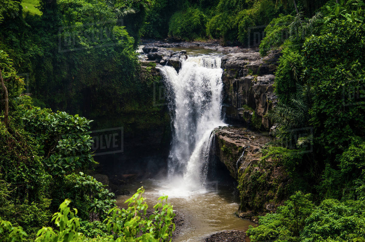 Waterfall flowing over rocky river in jungle, Ubud, Bali, Indonesia ...