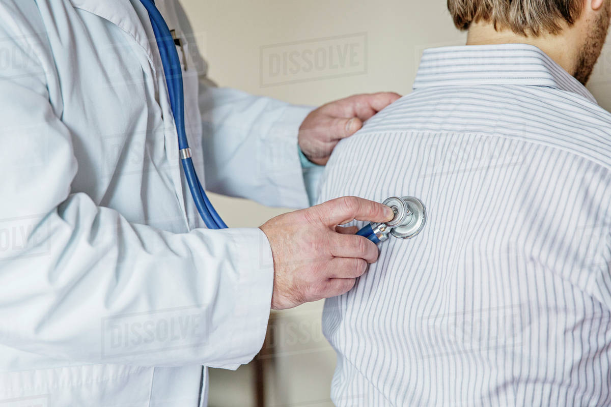 Caucasian doctor listening to heartbeat of patient - Stock Photo - Dissolve