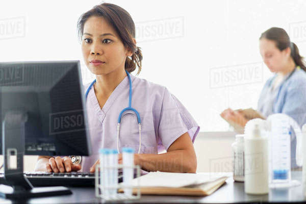 Nurse using computer in hospital - Stock Photo - Dissolve