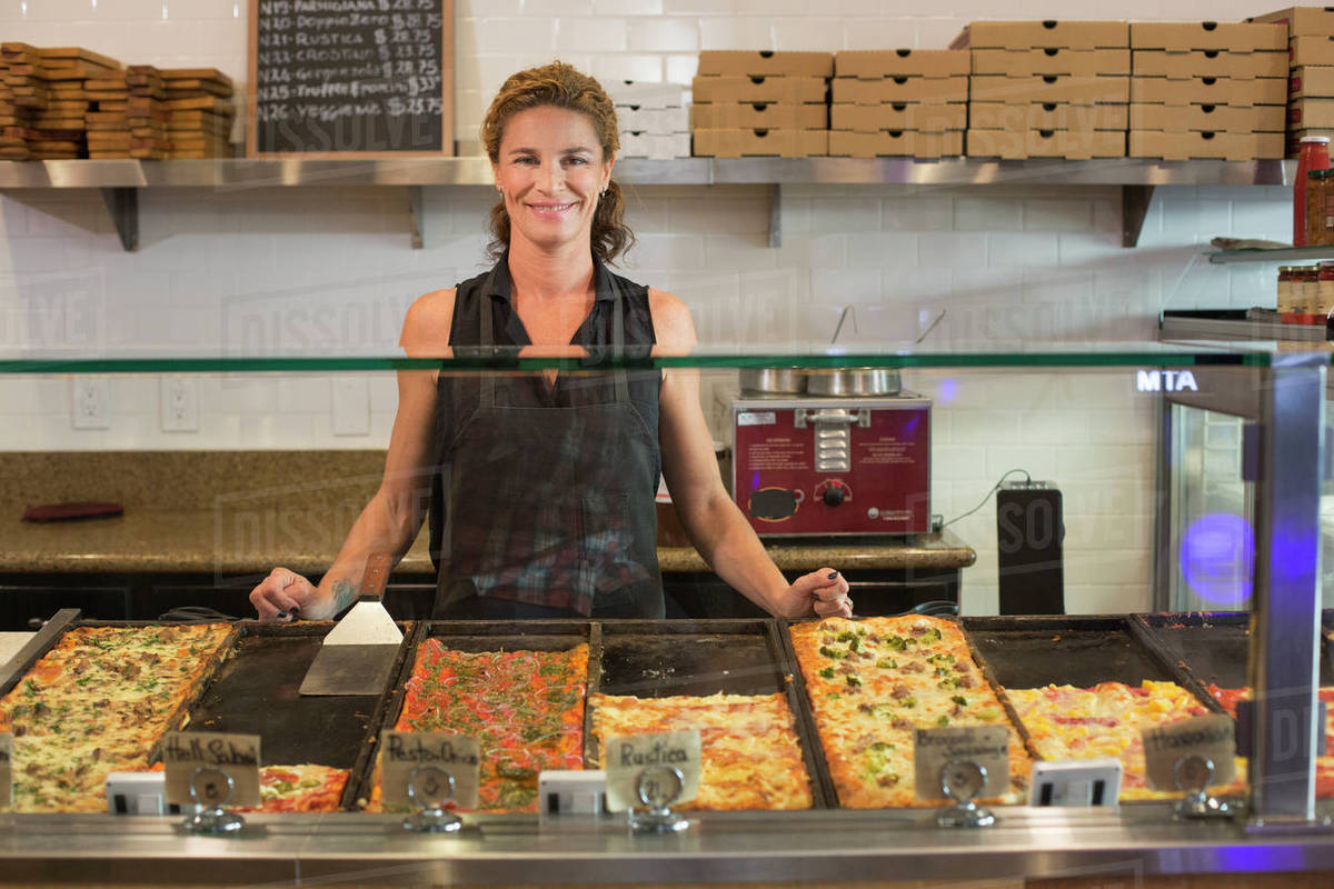 Caucasian server smiling in cafe - Royalty-free Stock Photo | Dissolve
