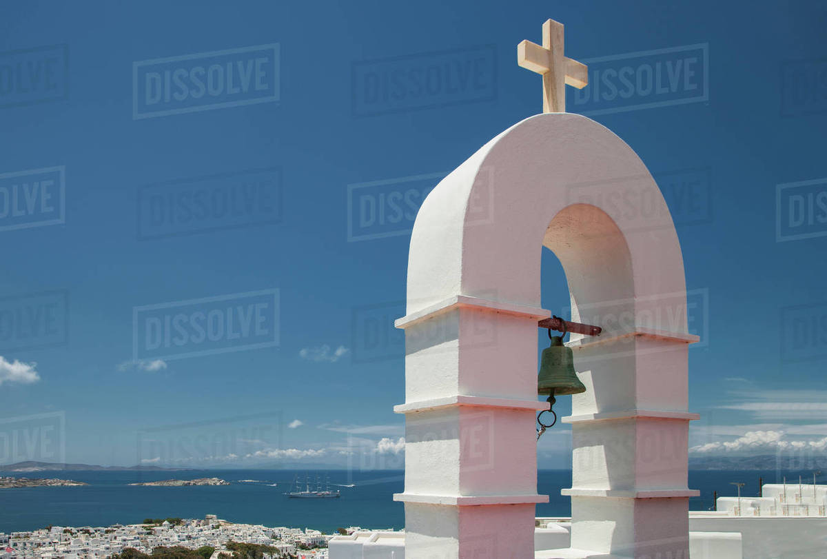 Bell arch and Mykonos cityscape under blue sky, Cyclades, Greece ...