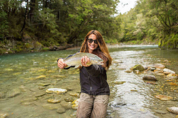 Caucasian woman catching fish in remote river - Royalty-free Stock ...