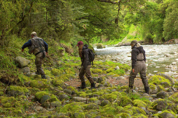 Caucasian friends walking in remote river - Stock Photo - Dissolve