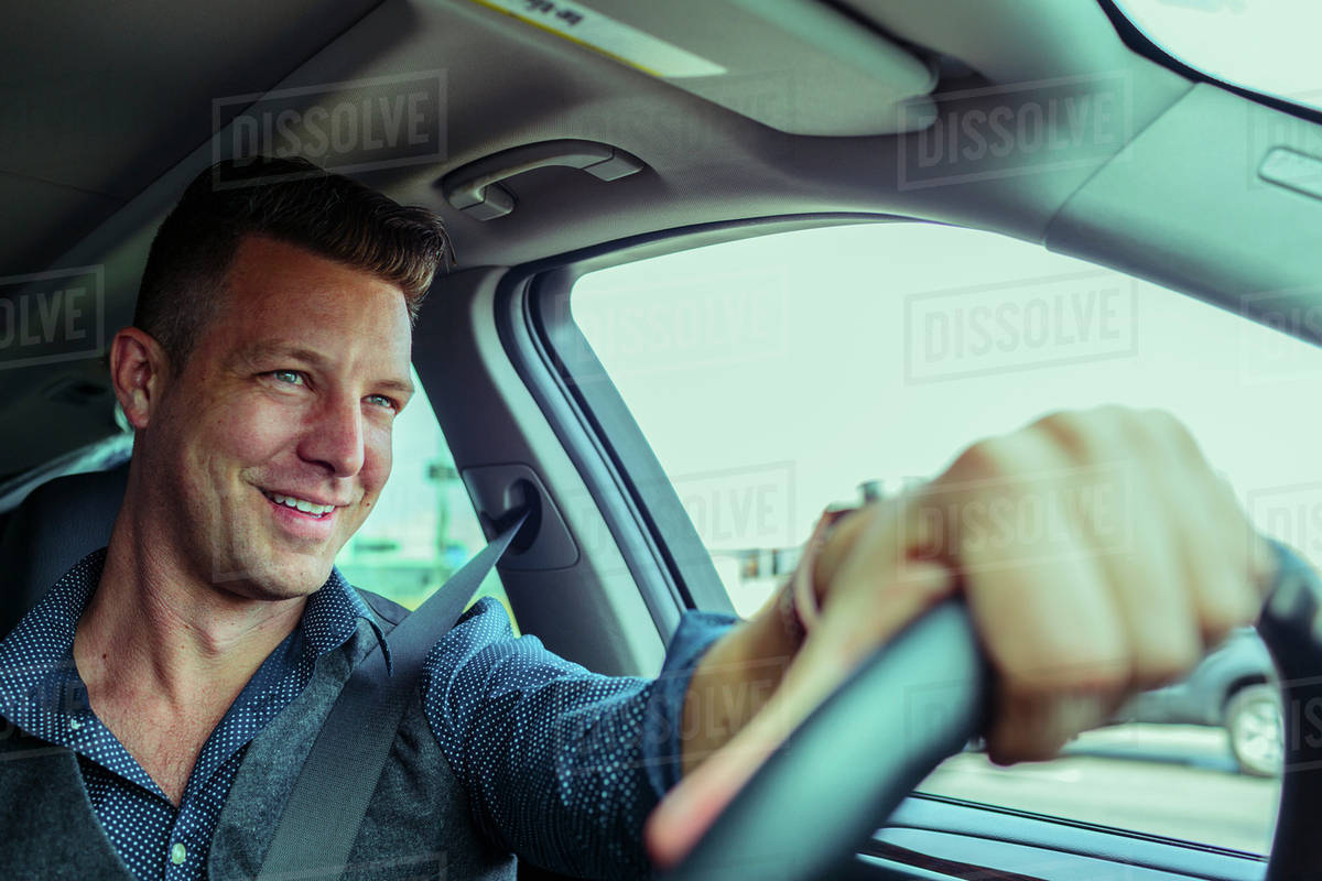 Smiling Caucasian man driving car - Royalty-free Stock Photo | Dissolve