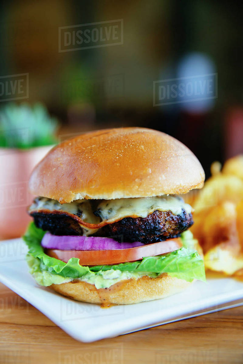 Close up of cheeseburger on plate - Stock Photo - Dissolve