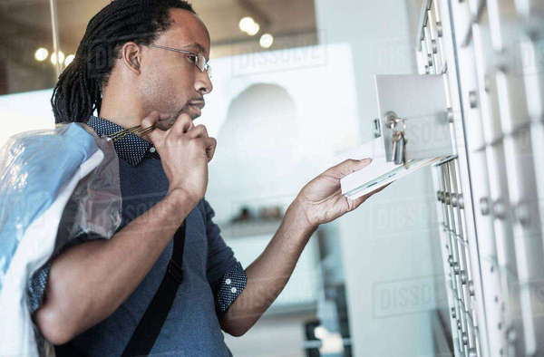 Black man gathering mail from post office box - Royalty-free Stock ...