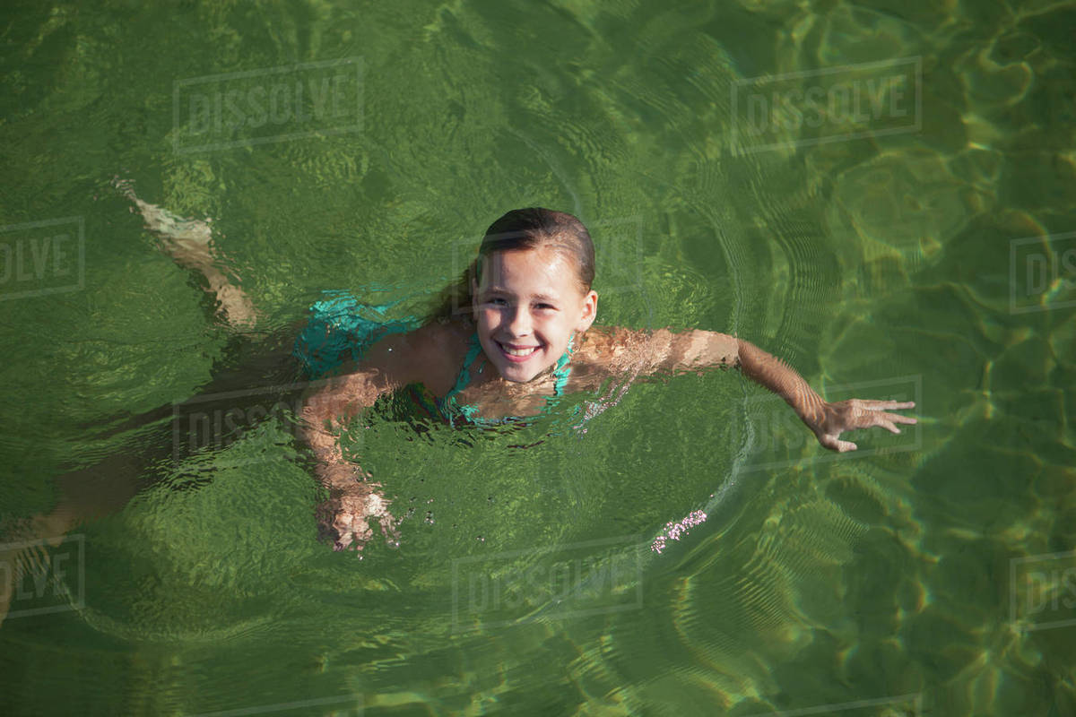 Caucasian girl swimming in lake - Royalty-free Stock Photo | Dissolve