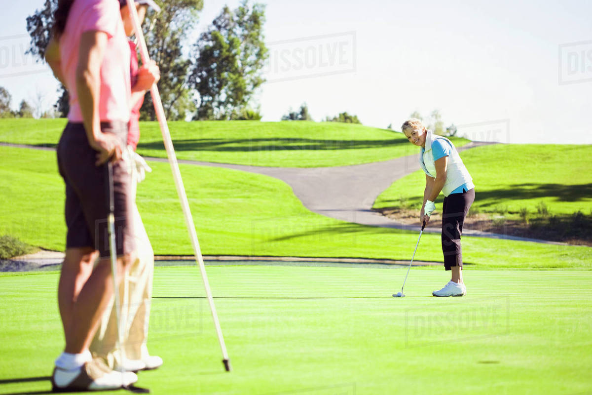 Women putting on green at golf course - Royalty-free Stock Photo | Dissolve