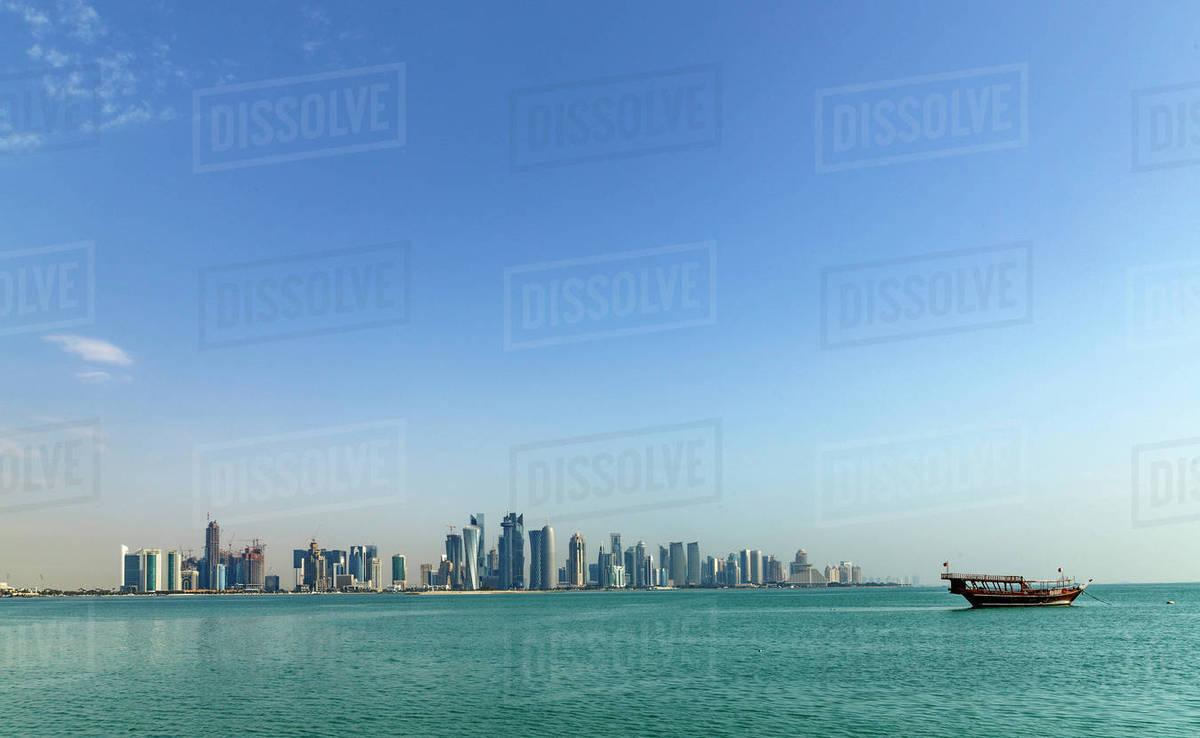Boat floating near Doha skyline, Doha, Qatar - Stock Photo - Dissolve