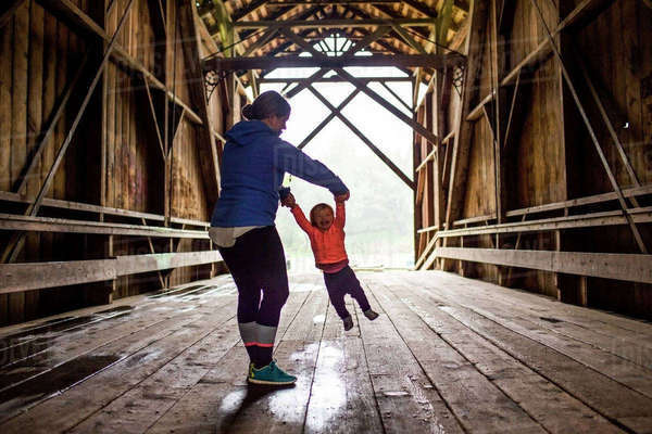 Caucasian mother and baby daughter on covered bridge - Stock Photo ...