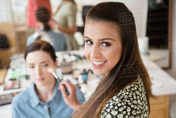 Makeup artist smiling with client - Stock Photo - Dissolve
