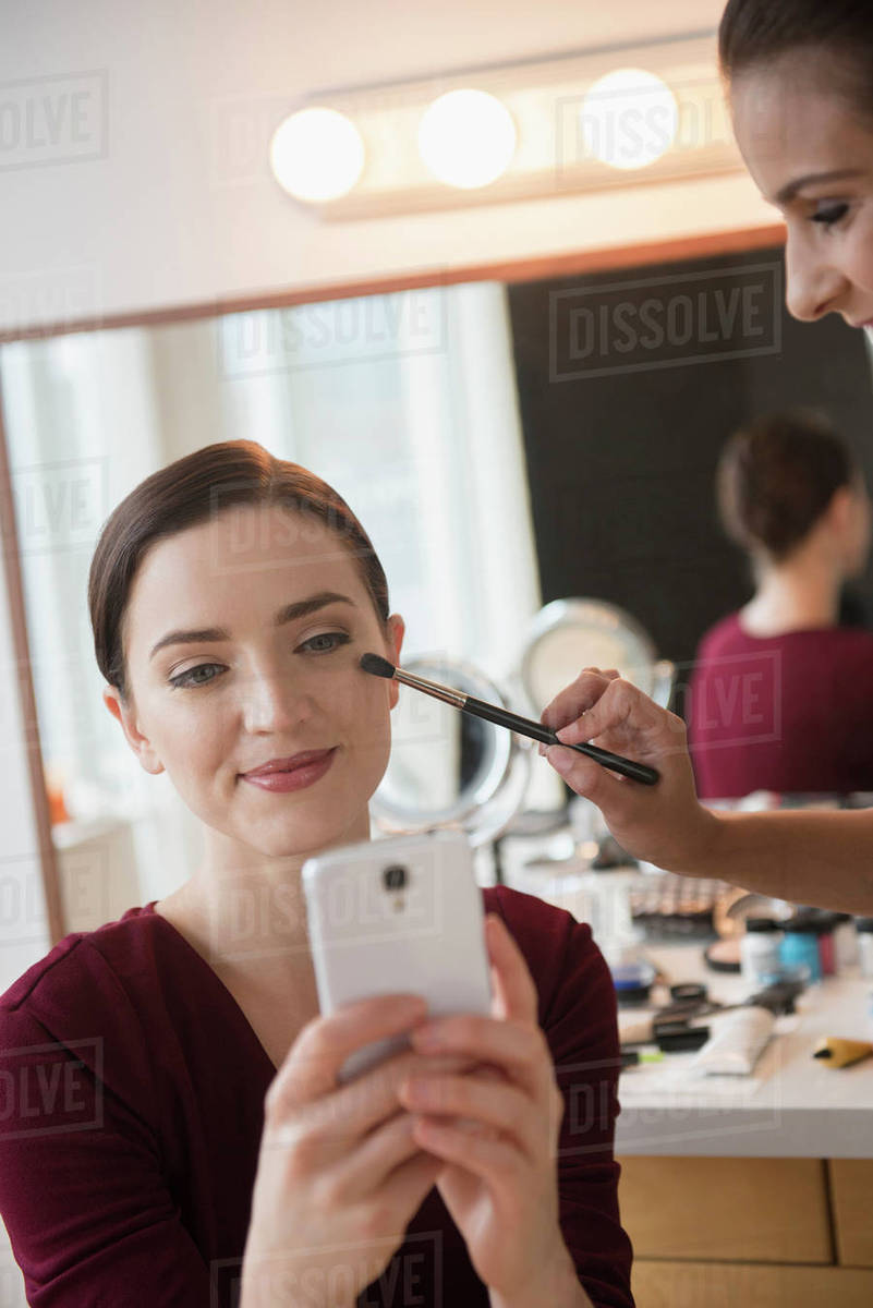 Woman having makeup applied by stylist - Stock Photo - Dissolve