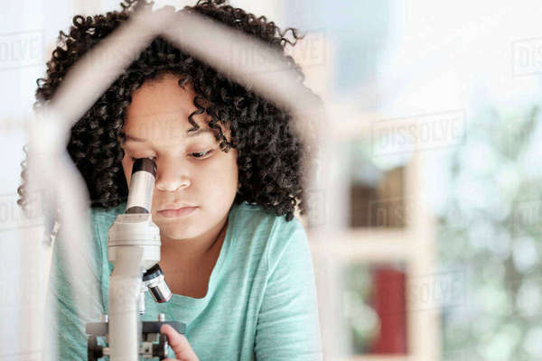 African American girl using microscope in science classroom - Royalty ...
