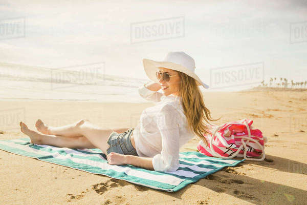 Caucasian woman laying on beach - Royalty-free Stock Photo | Dissolve