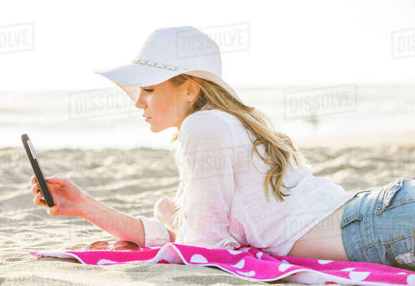 Caucasian woman using cell phone on beach - Royalty-free Stock Photo ...