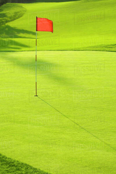 Flag in hole on golf course - Royalty-free Stock Photo | Dissolve