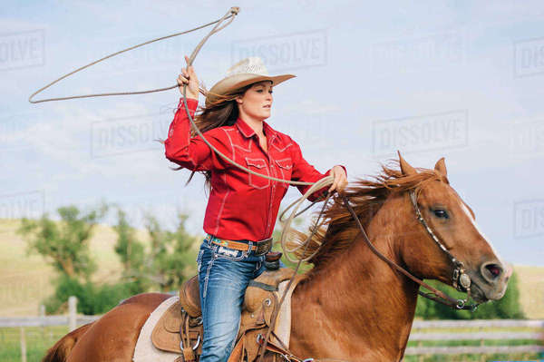 Caucasian cowgirl throwing lasso on horseback - Royalty-free Stock ...