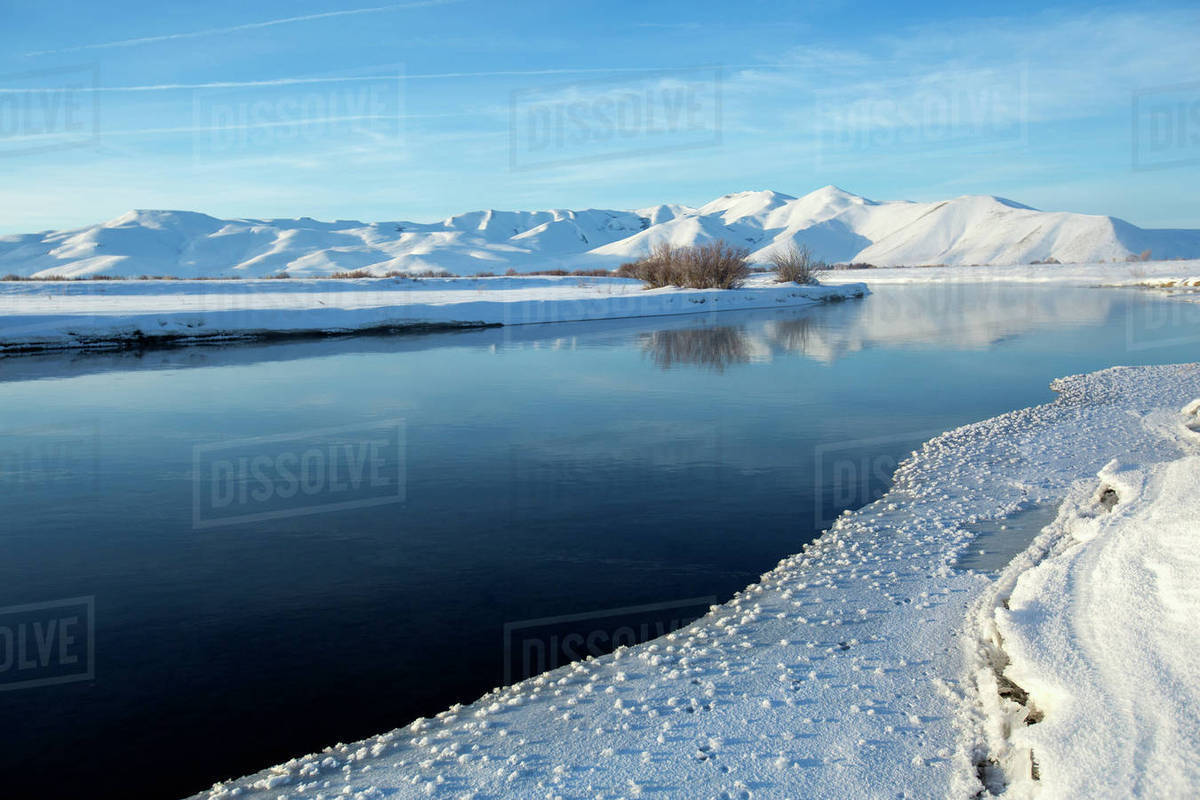 Still river in snowy remote landscape - Royalty-free Stock Photo | Dissolve
