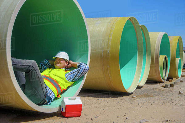 Caucasian construction worker napping inside large pipe - Royalty-free ...