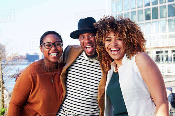 Friends smiling at waterfront - Royalty-free Stock Photo | Dissolve