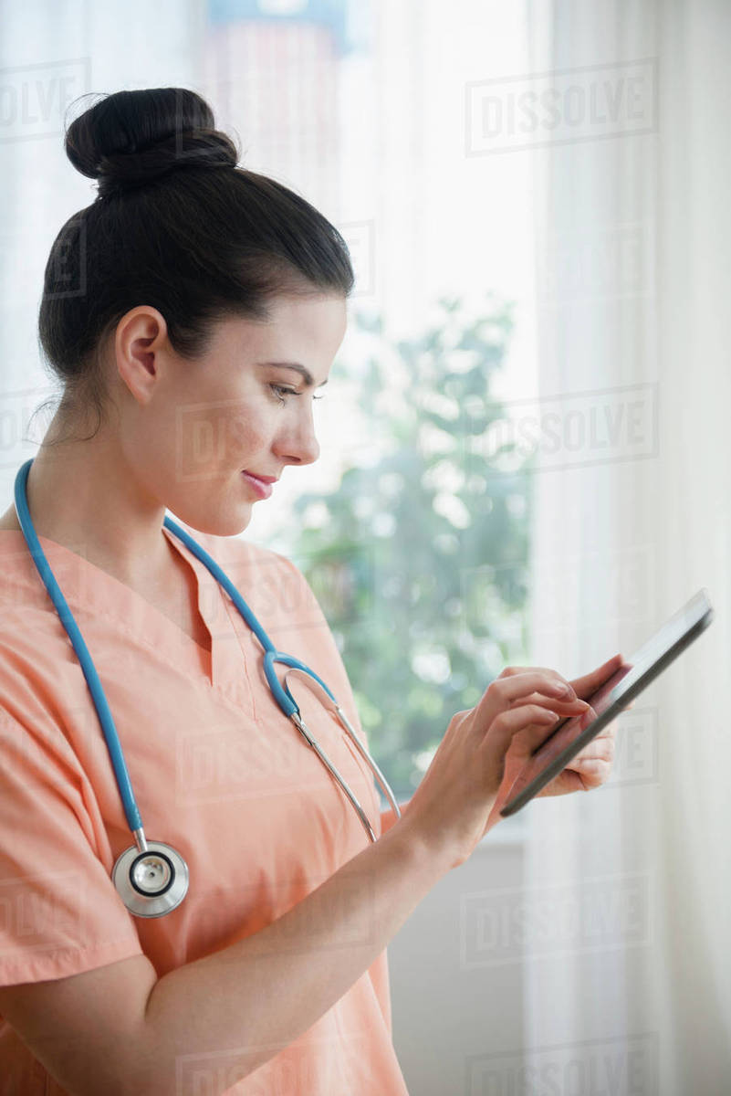Caucasian nurse using digital tablet - Royalty-free Stock Photo | Dissolve