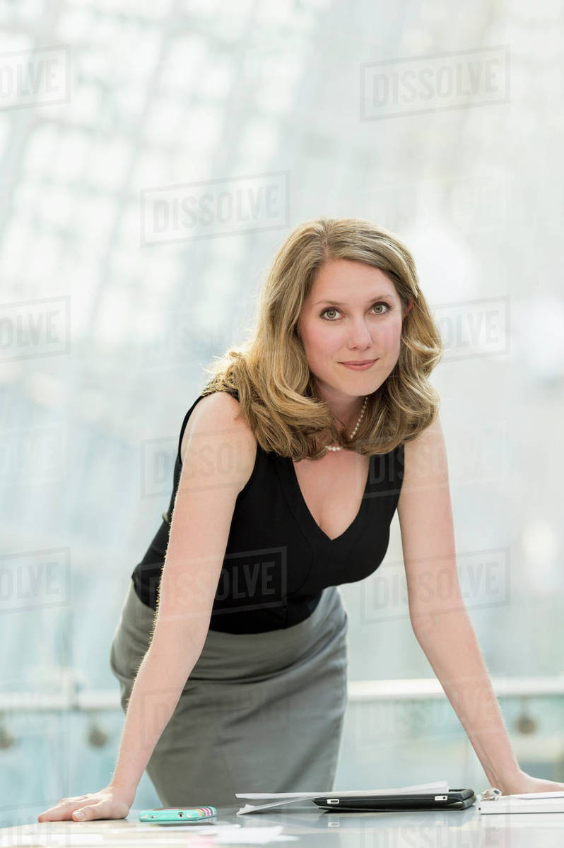 Caucasian businesswoman leaning on table - Royalty-free Stock Photo ...