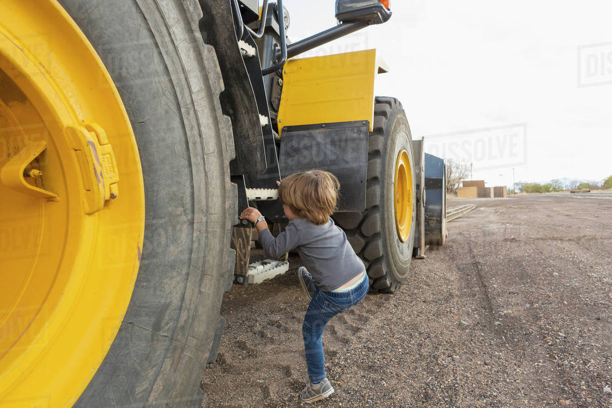 Caucasian boy climbing ladder on tractor - Royalty-free Stock Photo ...