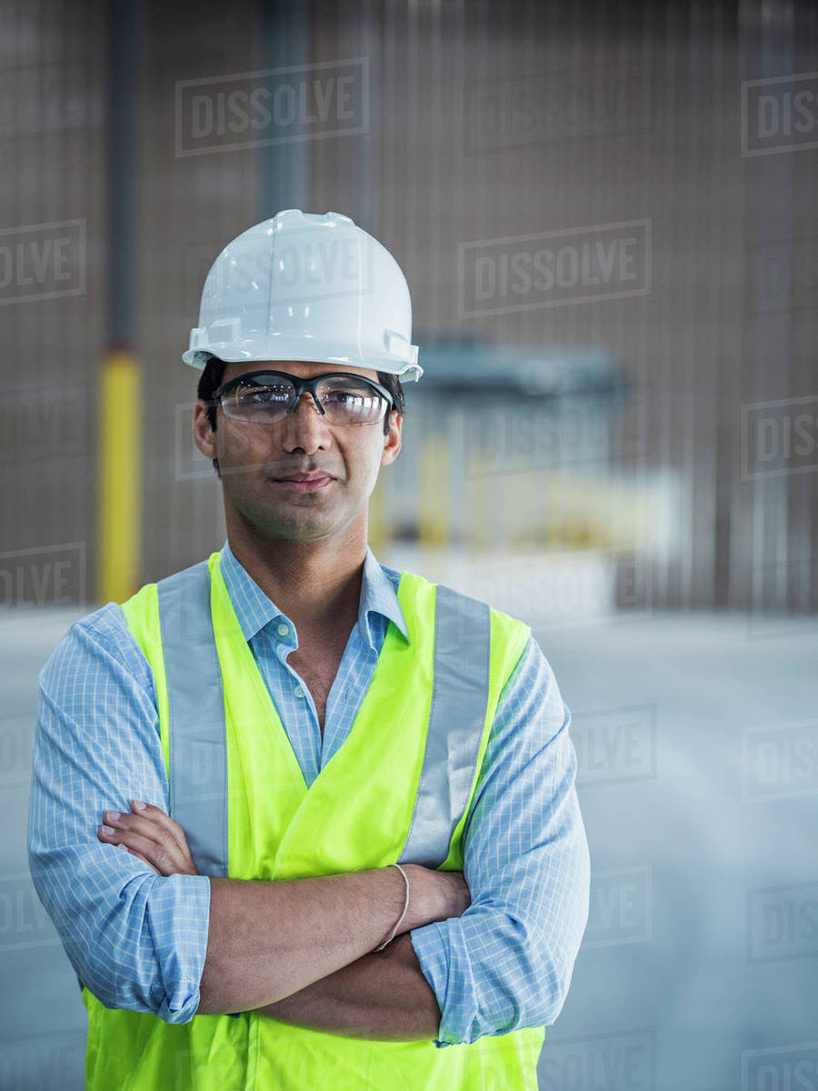 Serious Indian worker in empty warehouse - Stock Photo - Dissolve