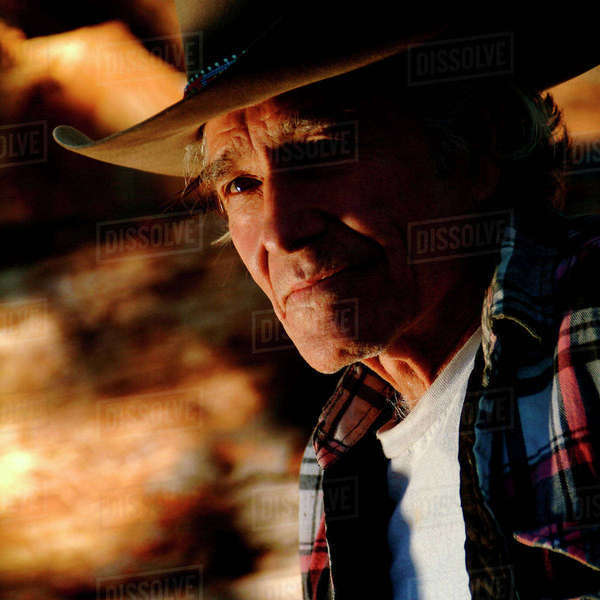 Man wearing cowboy hat looking at camera - Stock Photo - Dissolve
