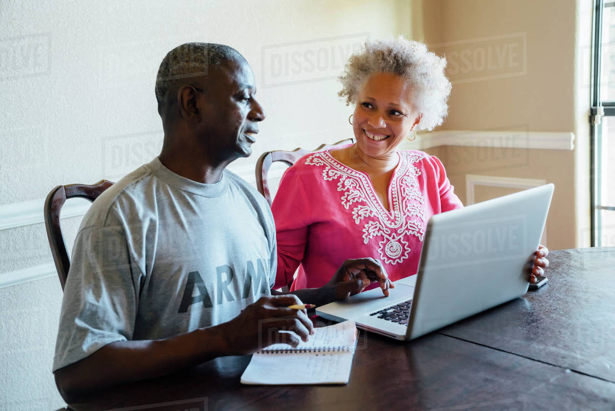 Black couple using laptop at table - Royalty-free Stock Photo | Dissolve