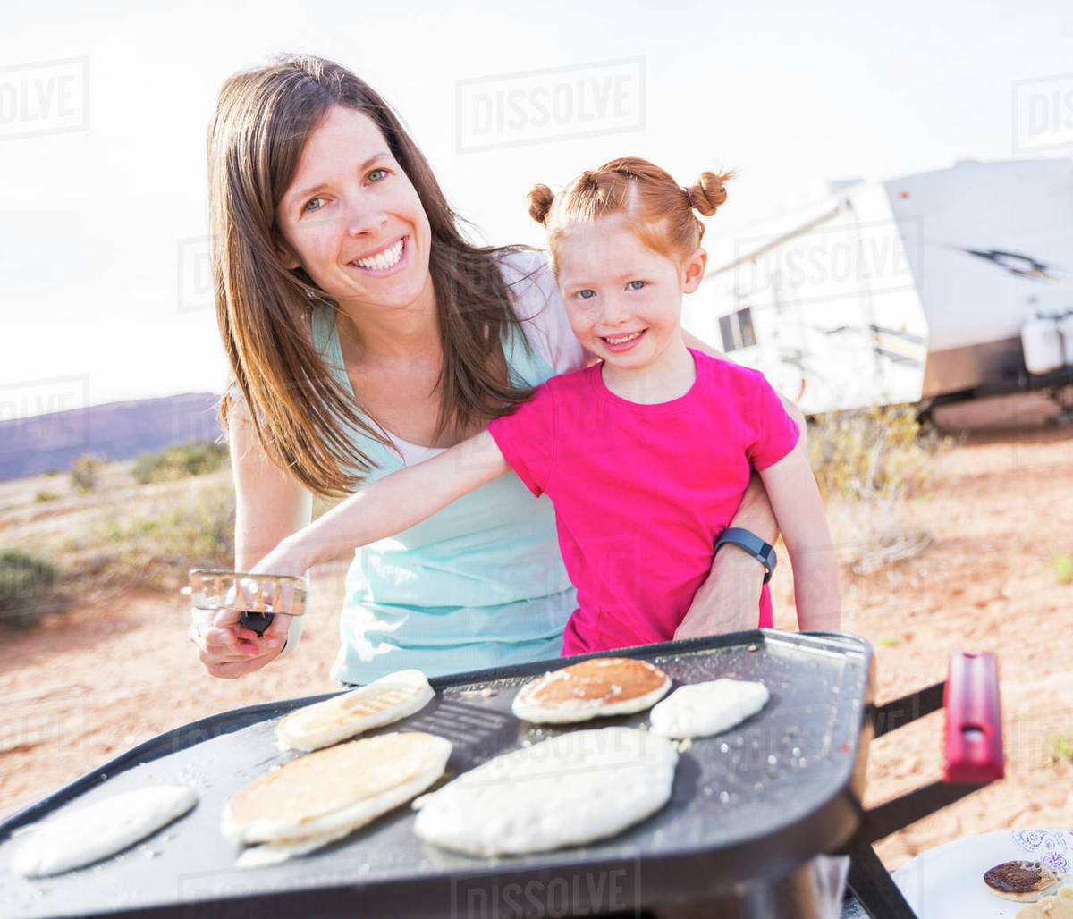 Caucasian mother and daughter making pancakes outdoors - Stock Photo ...