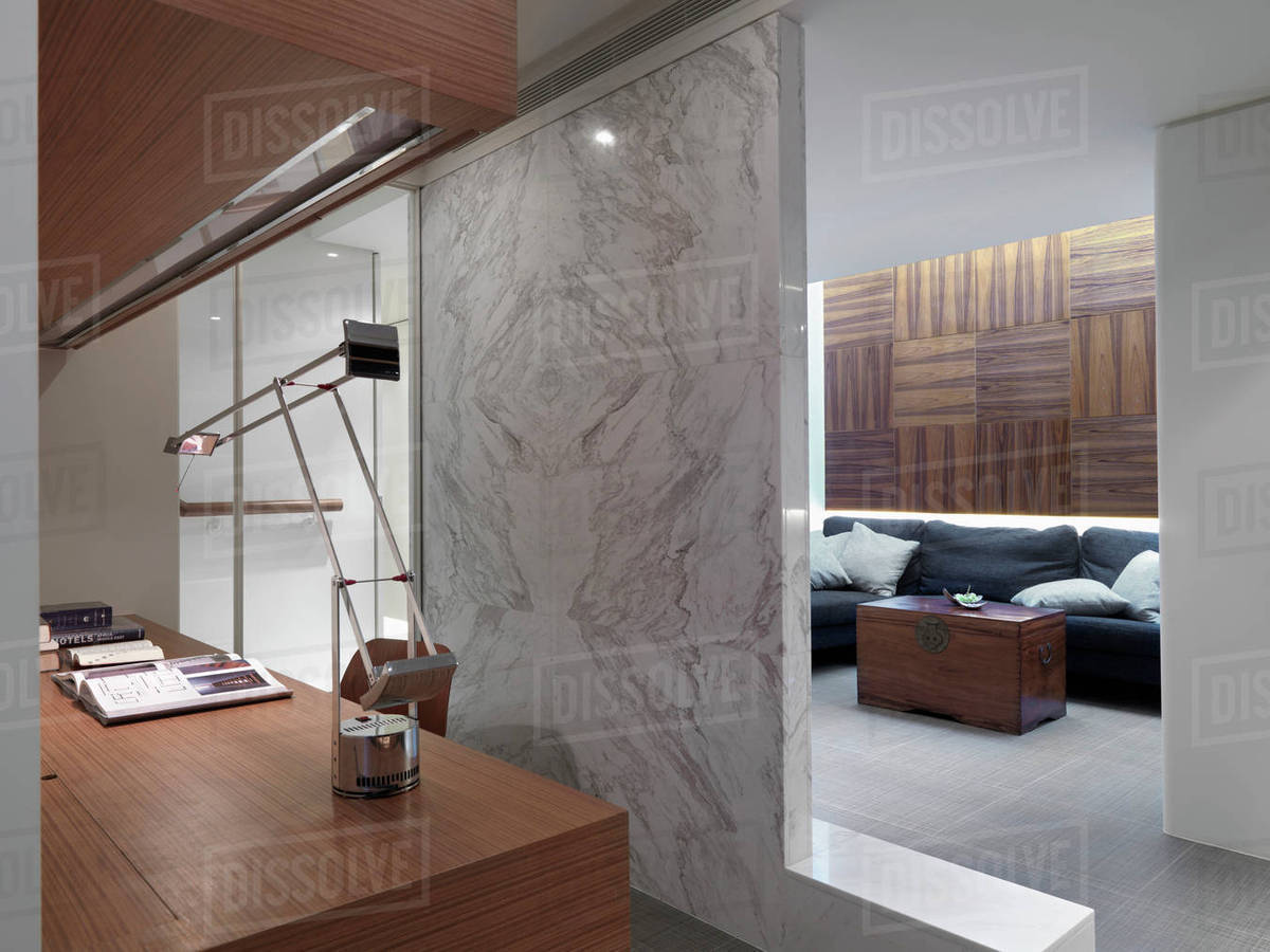 Marble wall dividing home office from living room - Stock Photo - Dissolve