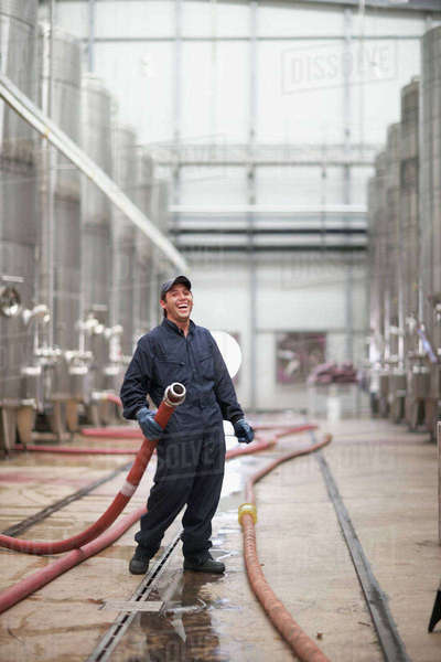 Chilean man holding industrial hose at winery - Royalty-free Stock ...