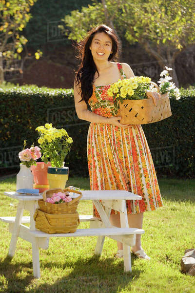 Chinese woman gathering flowers in garden - Royalty-free Stock Photo ...