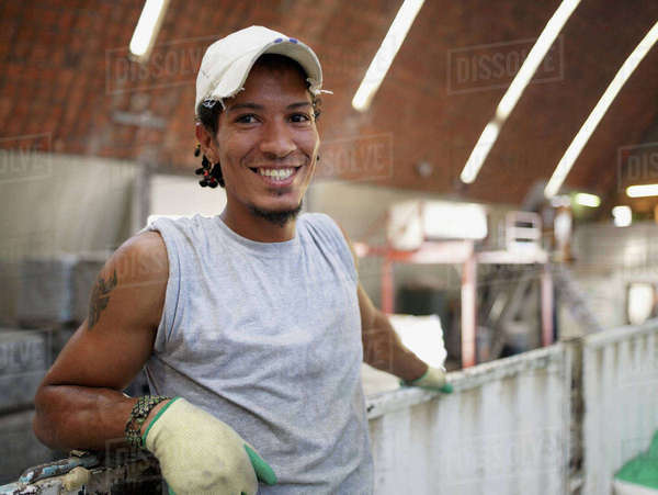 Hispanic worker smiling in factory - Royalty-free Stock Photo | Dissolve