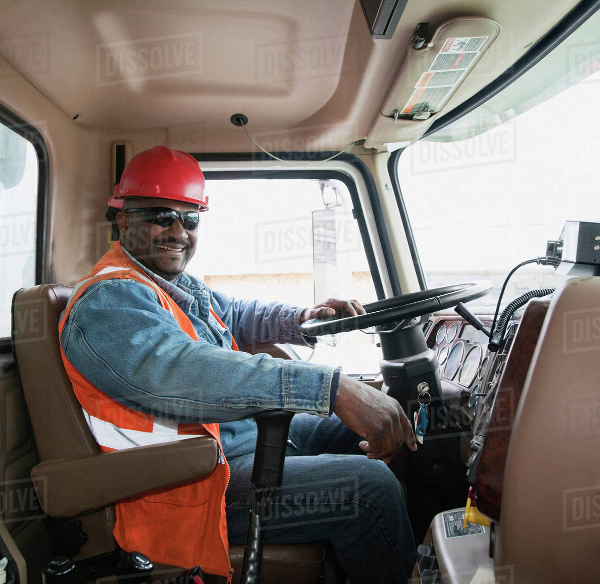 African construction worker driving truck - Stock Photo - Dissolve