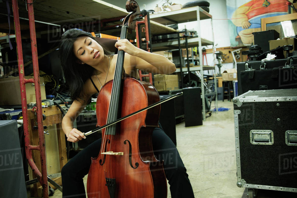 Asian woman playing cello in warehouse - Royalty-free Stock Photo ...