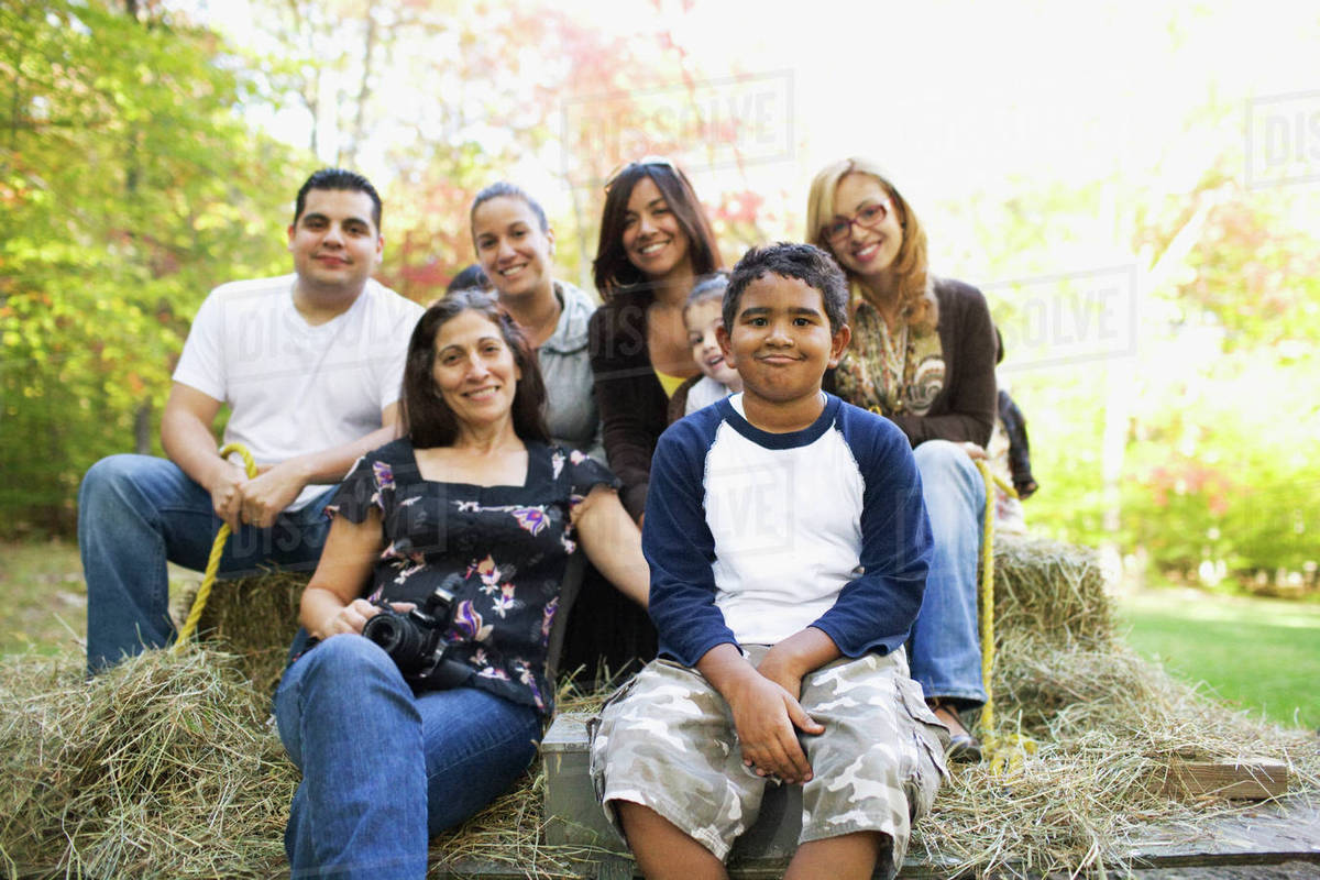 Adults and children sitting on hay ride - Stock Photo - Dissolve