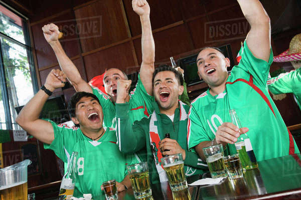 Cheering men watching television in sports bar - Stock Photo - Dissolve