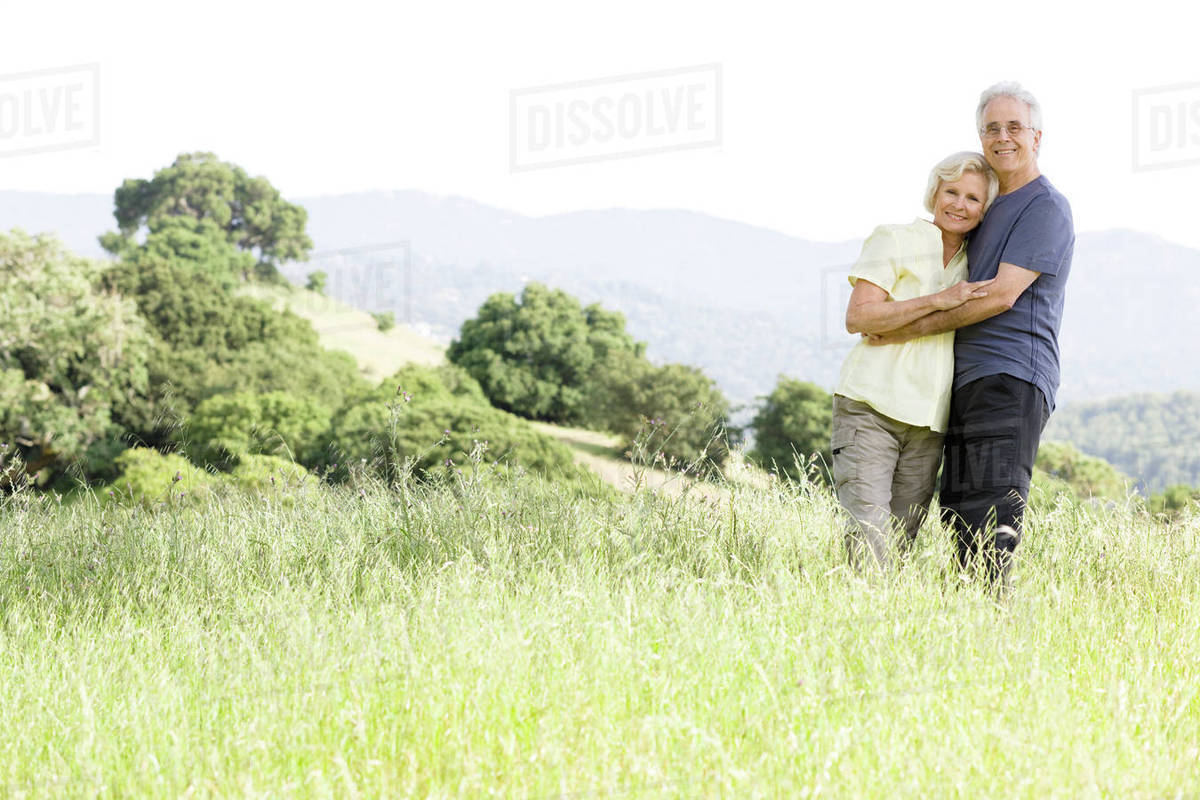Caucasian couple hugging in field - Royalty-free Stock Photo | Dissolve
