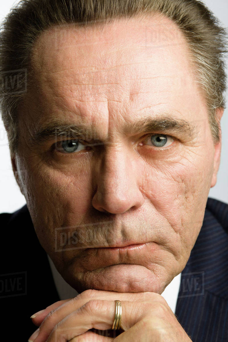 Serious Caucasian businessman with hands on chin - Royalty-free Stock ...