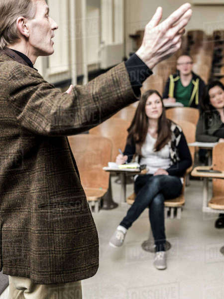 Teacher talking to students in classroom - Stock Photo - Dissolve