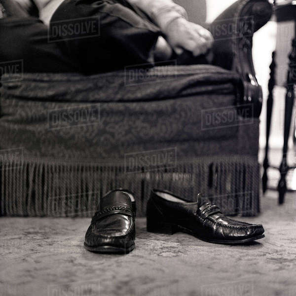Man's shoes on floor in living room - Royalty-free Stock Photo | Dissolve