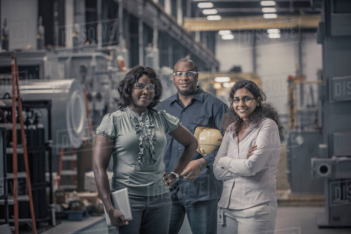 Workers standing together in factory - Royalty-free Stock Photo | Dissolve