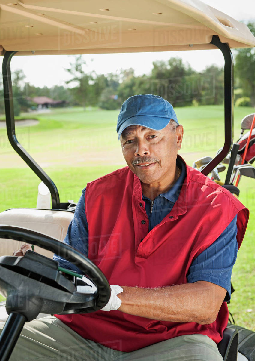 Black man driving golf cart - Stock Photo - Dissolve