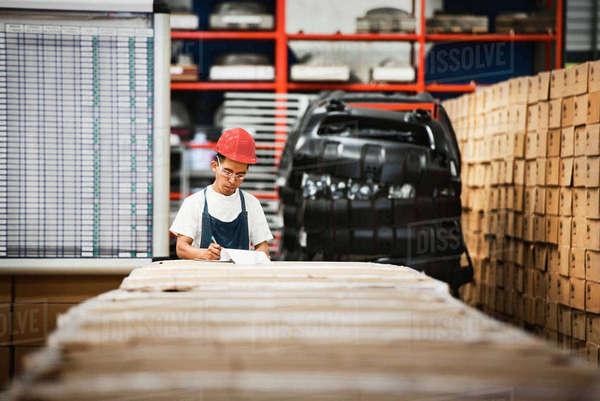 Worker examining product in manufacturing plant - Stock Photo - Dissolve
