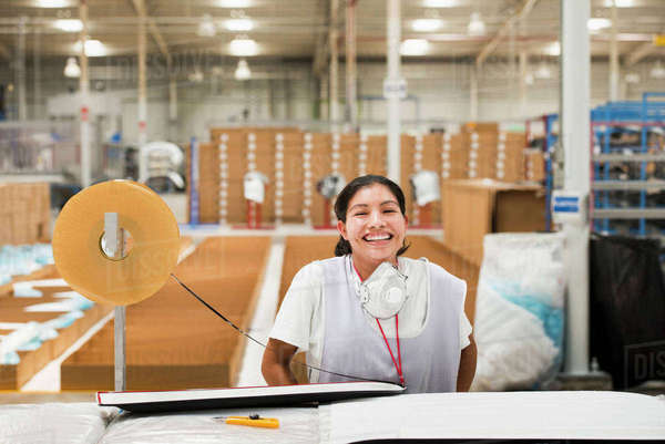 Worker smiling in manufacturing plant - Stock Photo - Dissolve