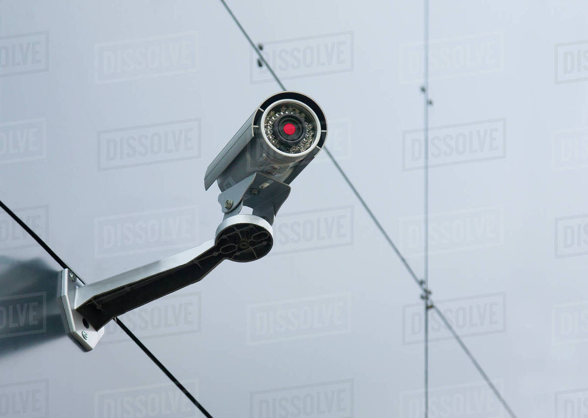A security camera mounted on the wall of a building - Royalty-free ...