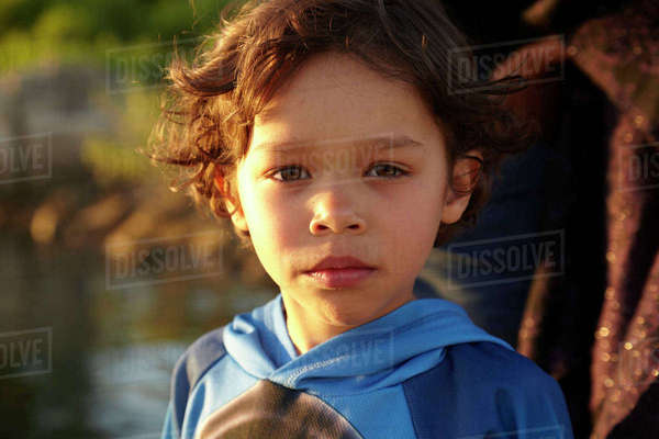 Mixed race boy with serious expression - Stock Photo - Dissolve