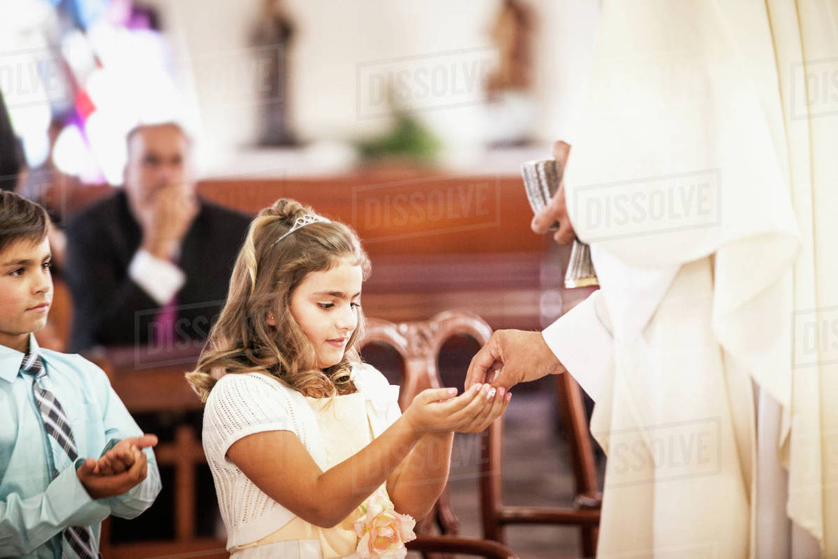 Girl taking her first communion at church - Stock Photo - Dissolve